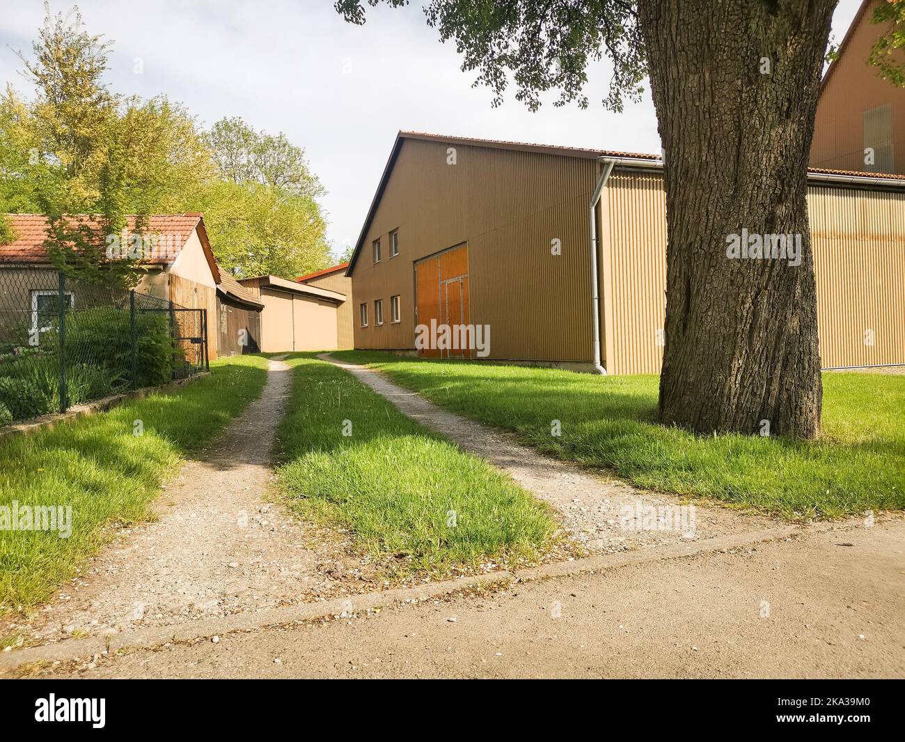 Traditional German farm with gravel path, cherry tree and fence Stock ...