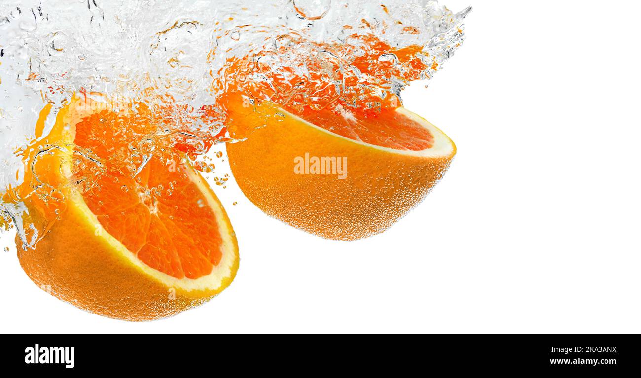 Red Oranges halves falling in water with splash on white background ...
