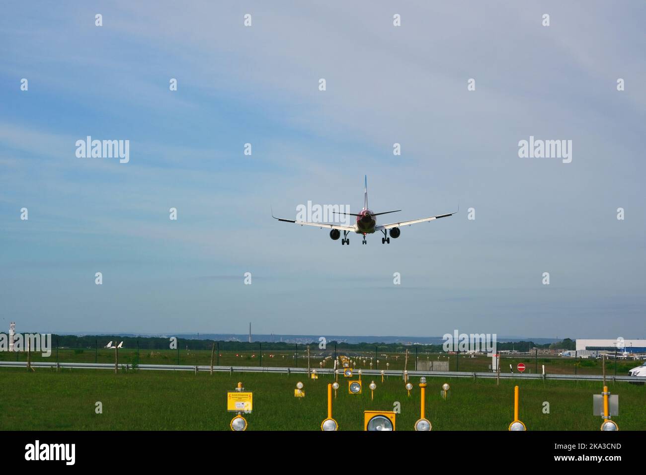 airplane on approach for landing, rear view just before landing, blue ...
