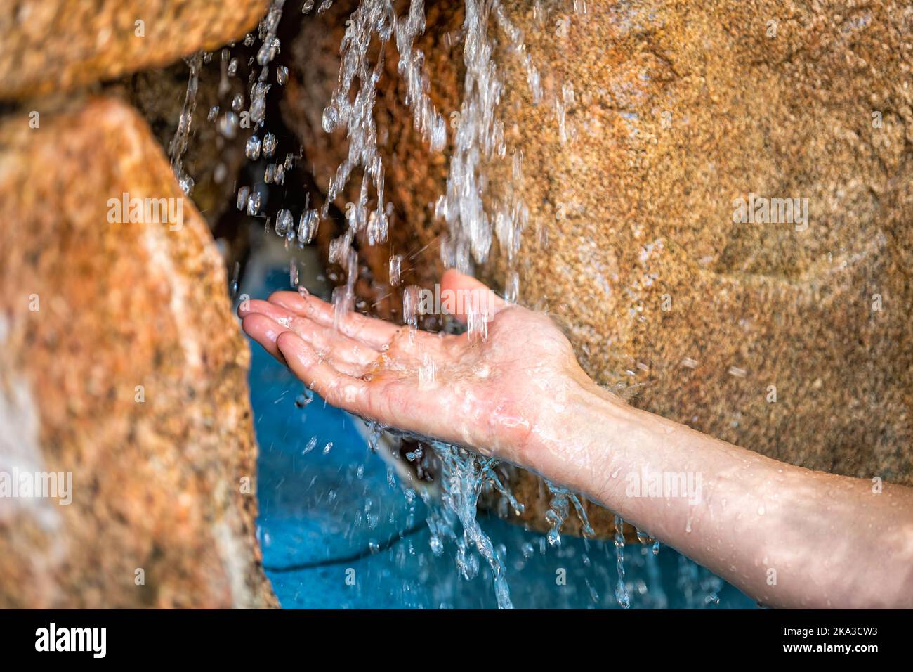 Young man hands closeup with water splash drops in Japanese hot spring ...