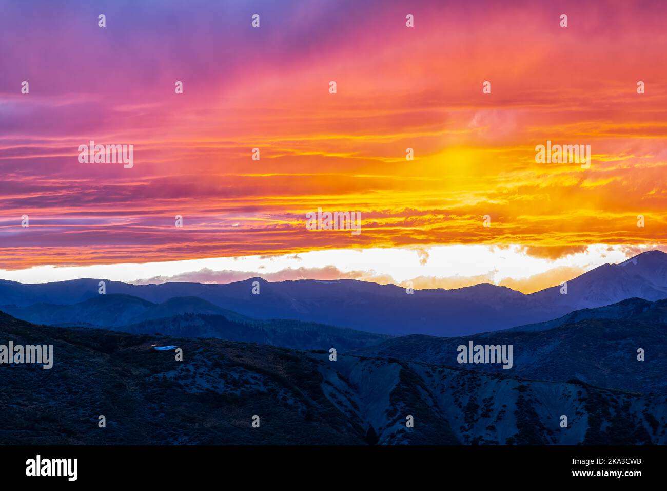 Aspen, Colorado rocky mountains range silhouette at vibrant colorful sunset of orange purple ...