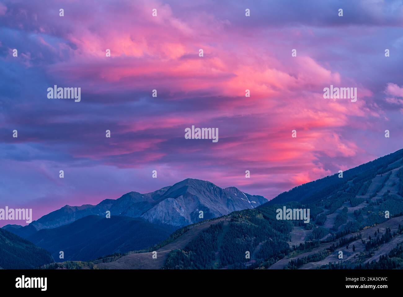 Pink purple sunset in Aspen, Colorado with Rocky mountains of Buttermilk ski slope mountain in ...