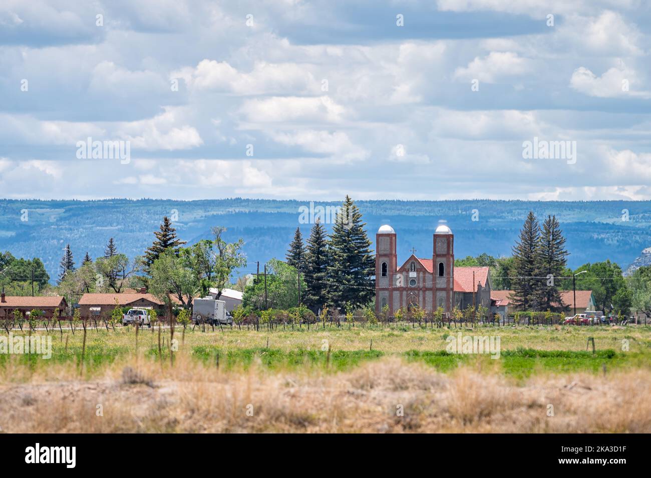 Highway 285 with cityscape of Conejos and oldest church in Colorado in ...