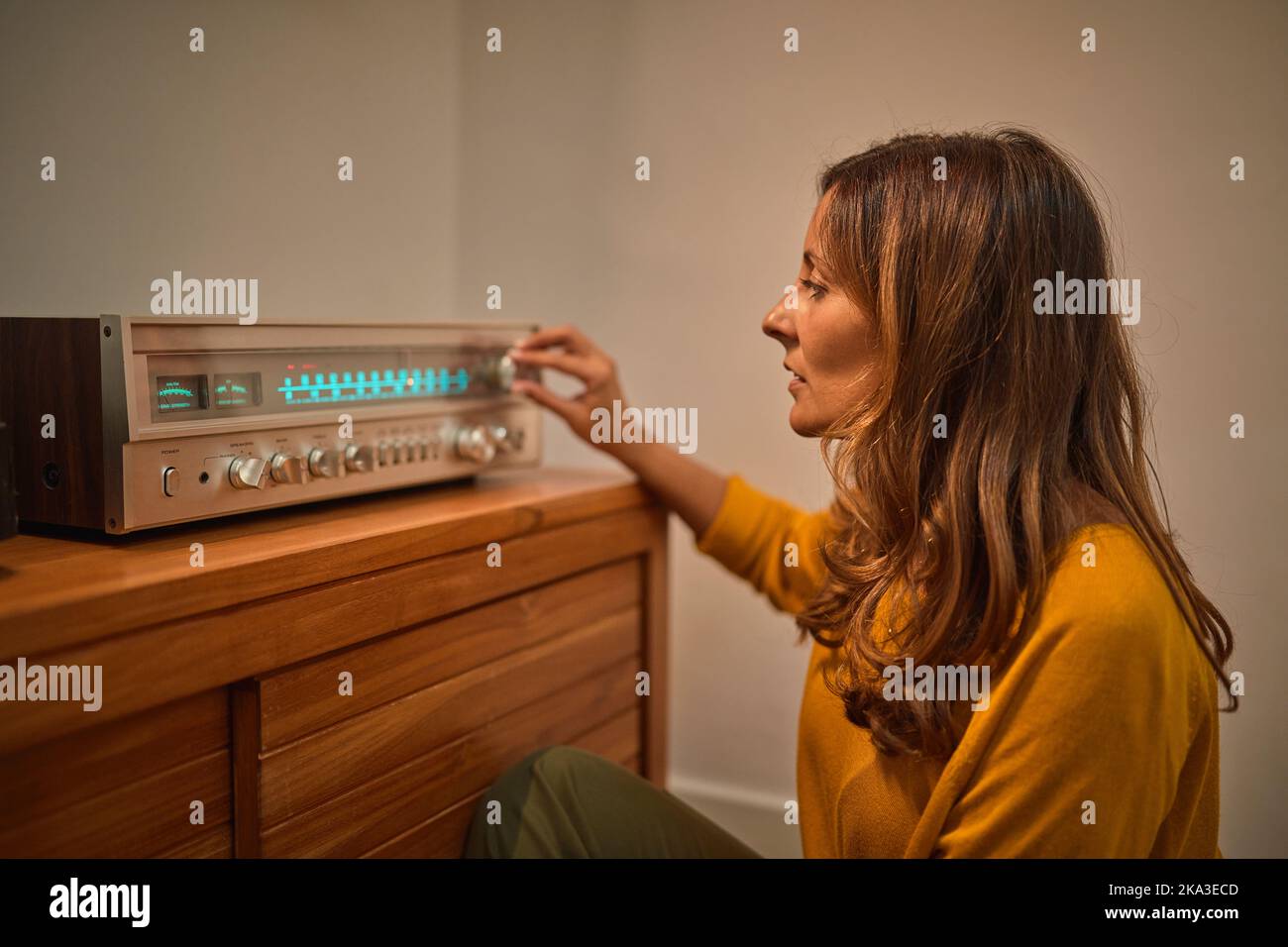 Side view of fair haired female changing sound volume on old fashioned ...