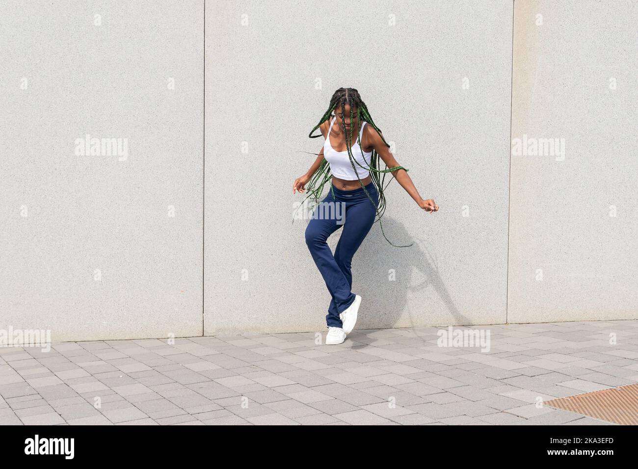 Full body of young stylish African American female with long braided ...