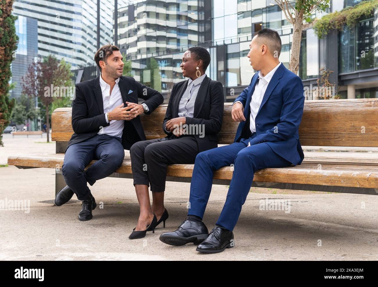 Full body of positive multiracial coworkers in formal suits sitting on ...