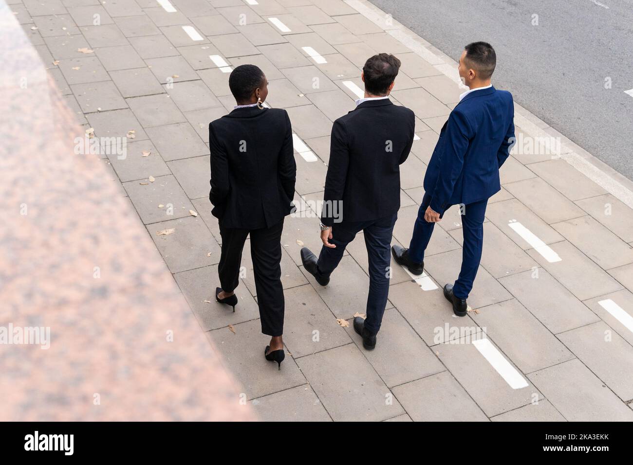 From above back view of multiracial coworkers in formal outfits walking ...