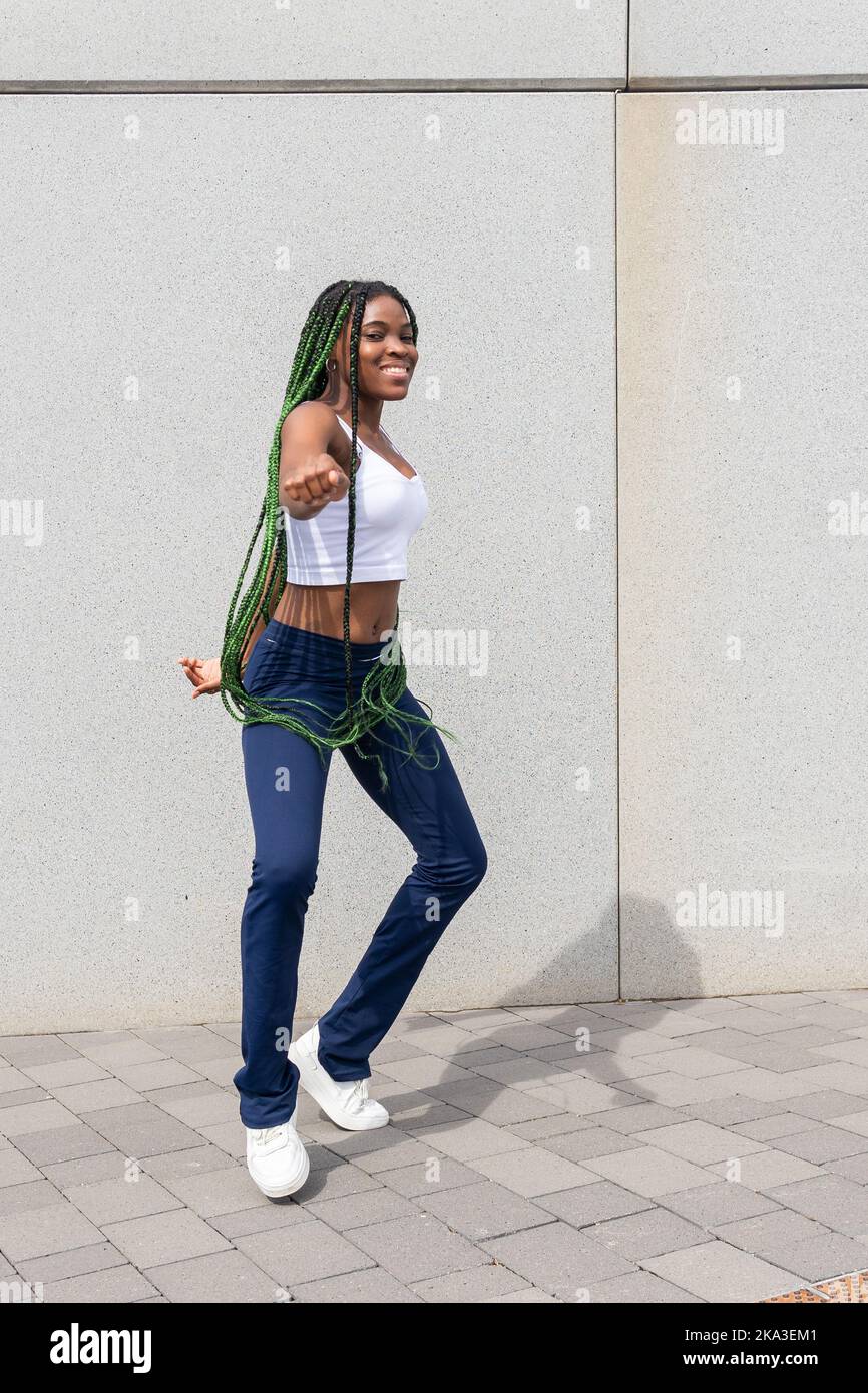 Full body of young stylish African American female with long braided ...