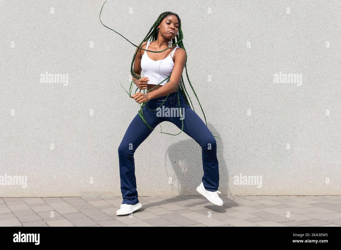 Full body of young stylish African American female with long braided ...