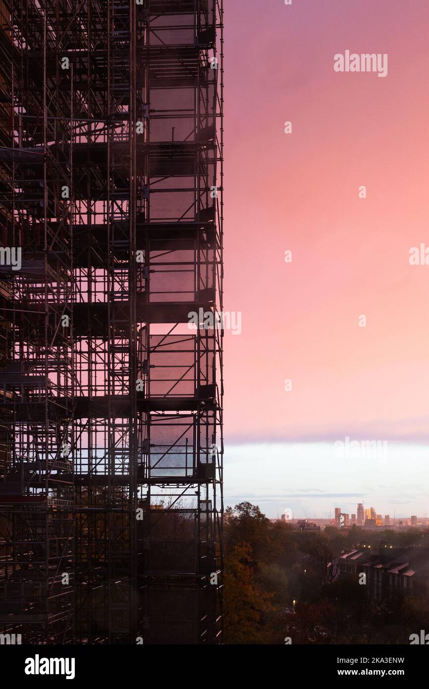 Scaffolding around modern building during renovations with sunset sky ...