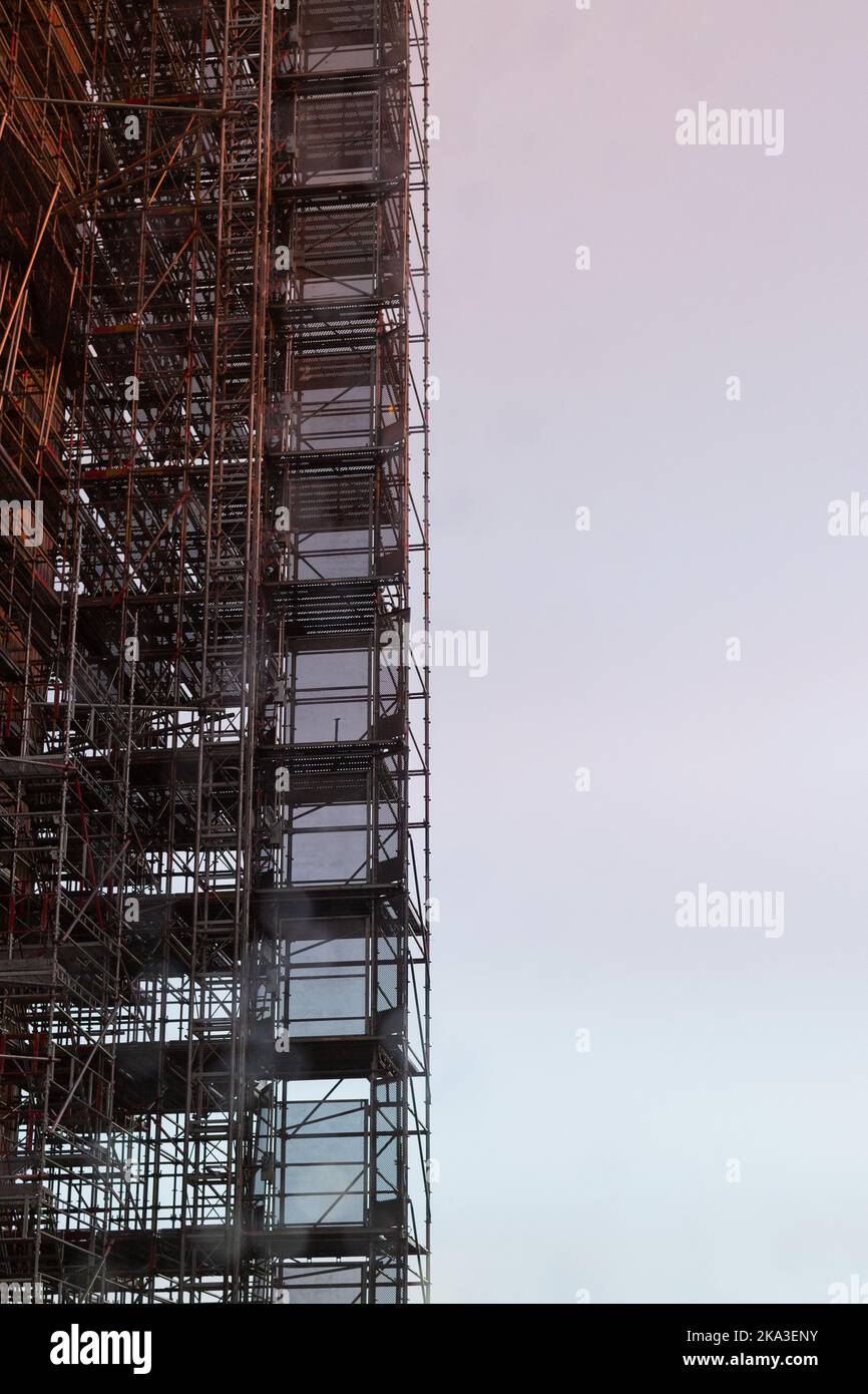 Scaffolding around modern building during renovations with sunset sky ...