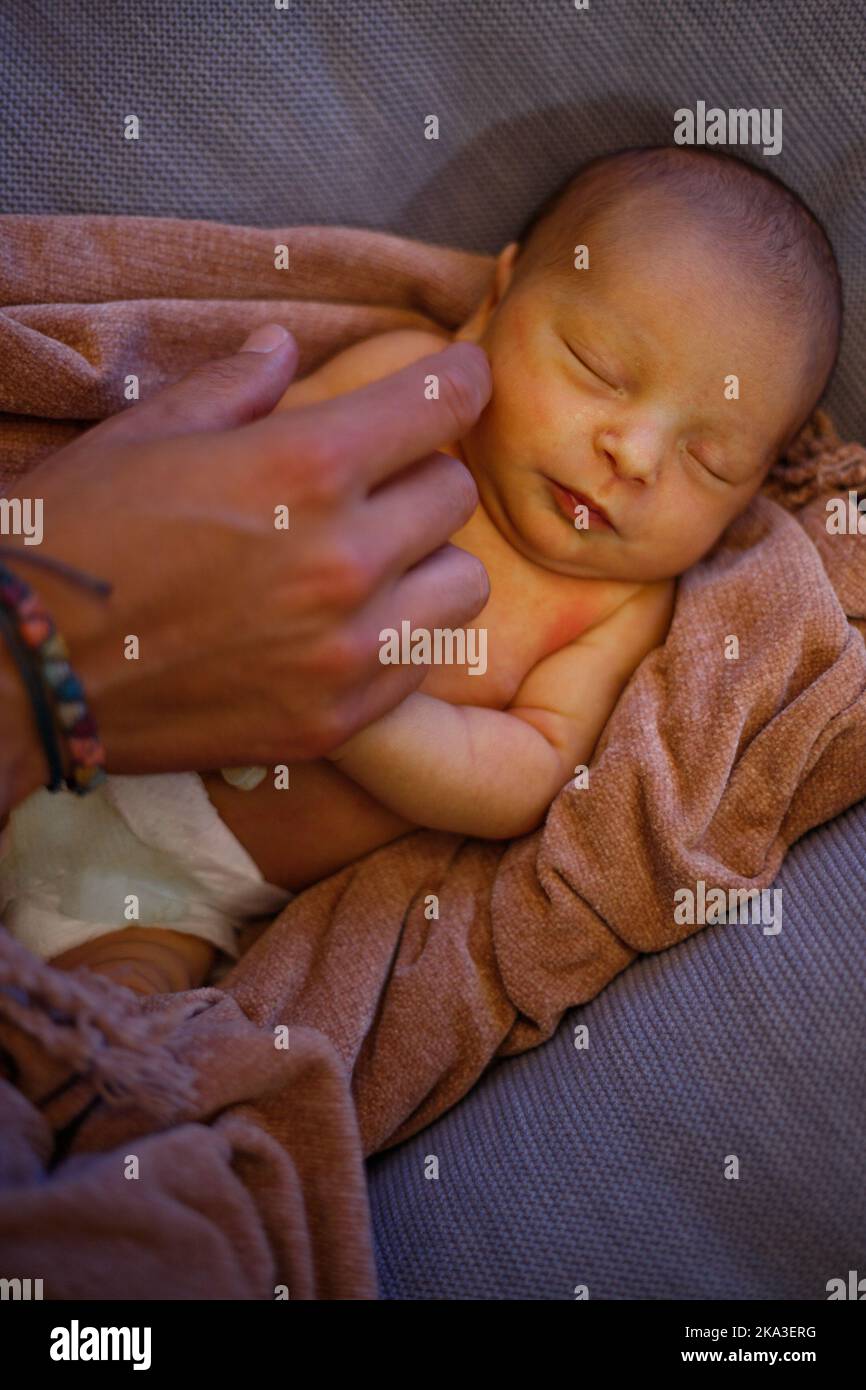 High angle of unrecognizable dad gently putting adorable infant baby in ...