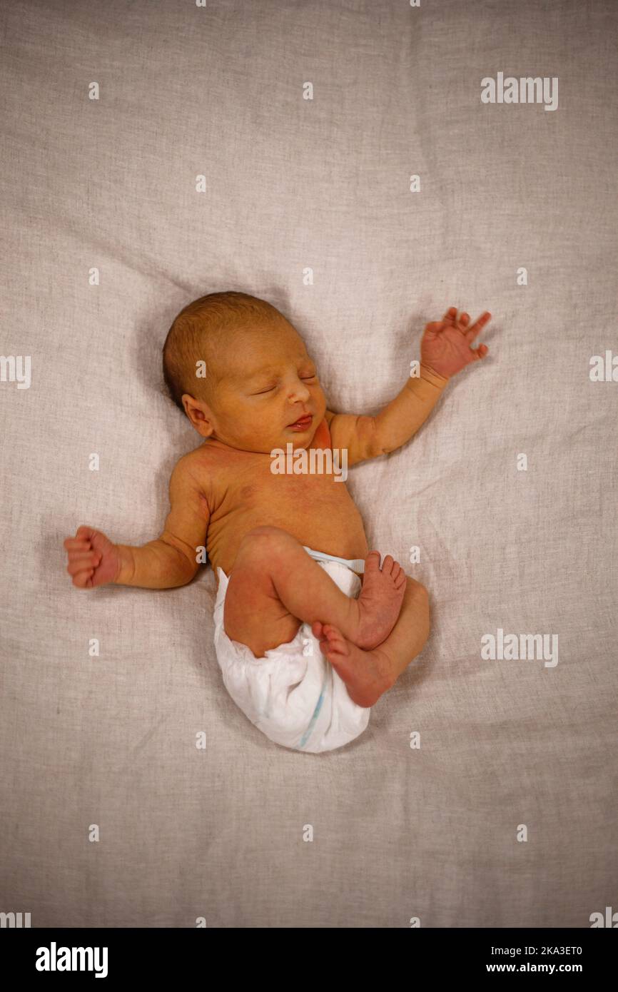 Top view of adorable infant baby in diaper lying on soft blanket with ...