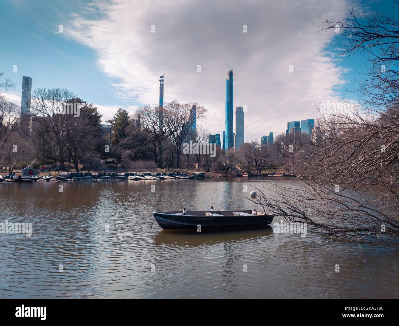 Empty rowboat floating on rippling water of lake surrounded with ...