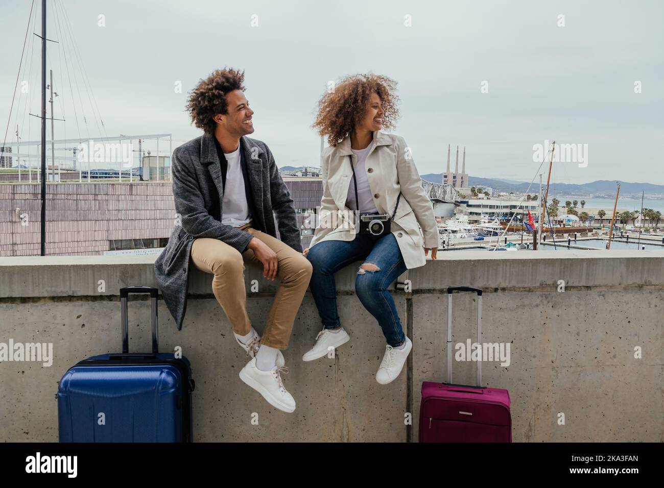Full body of African American male and female tourists talking while ...