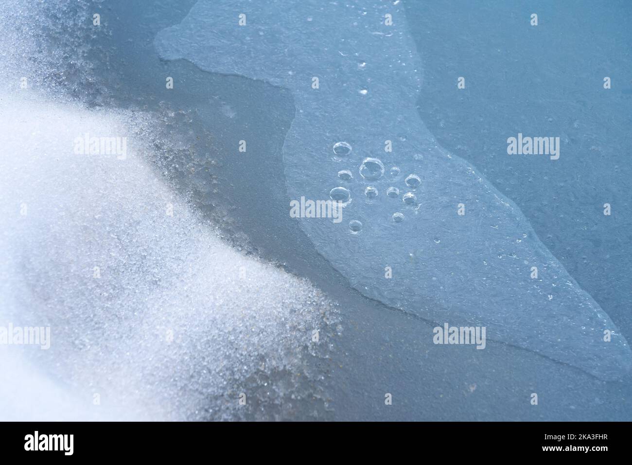 Abstract background of bubbles of air under layer of thin ice in clear ...