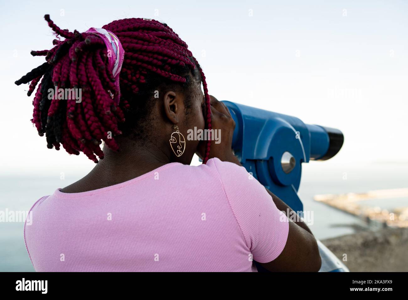Back view of anonymous African American female with dreadlocks looking ...