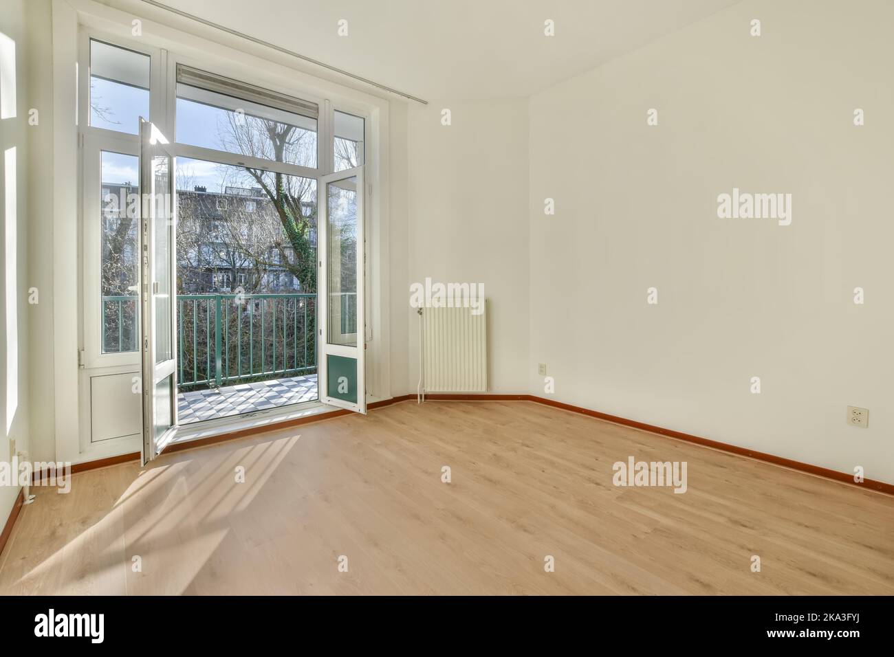 Empty room with opened doors of balcony with metal fence overlooking ...