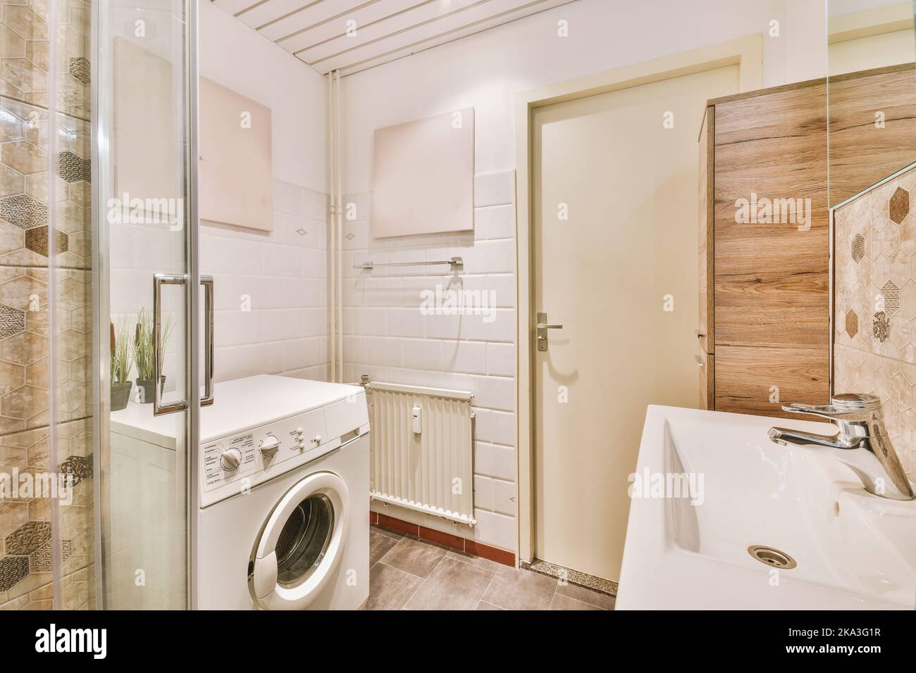 Sinks with mirrors and clean washing machine located near shower box ...