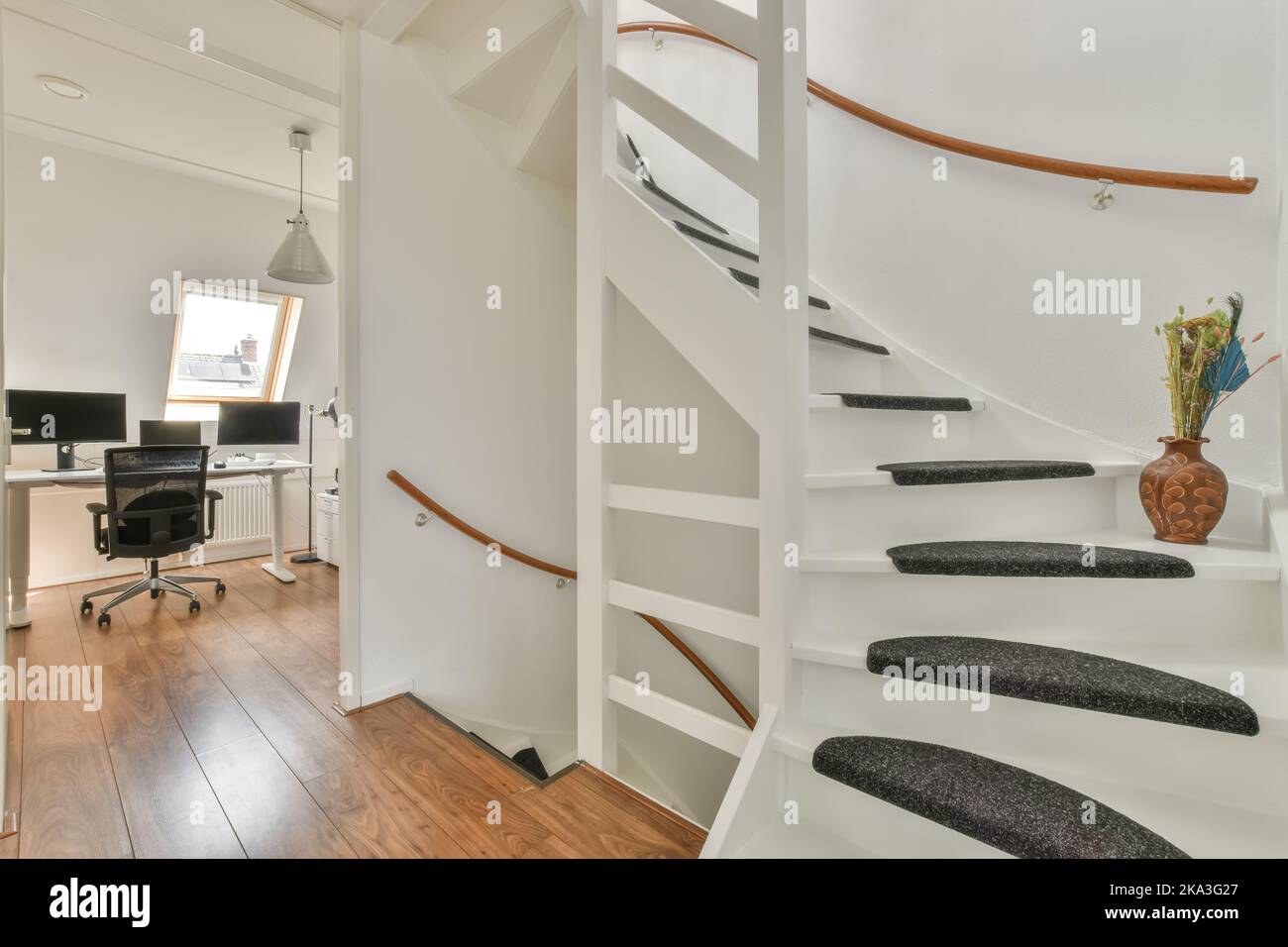 Staircase located in light corridor leading to study room with desk ...
