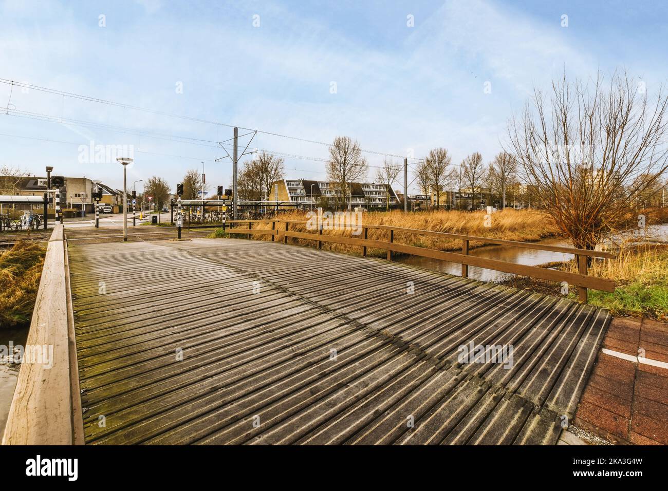 Peaceful scenery of wooden footbridge over calm river flowing amidst ...