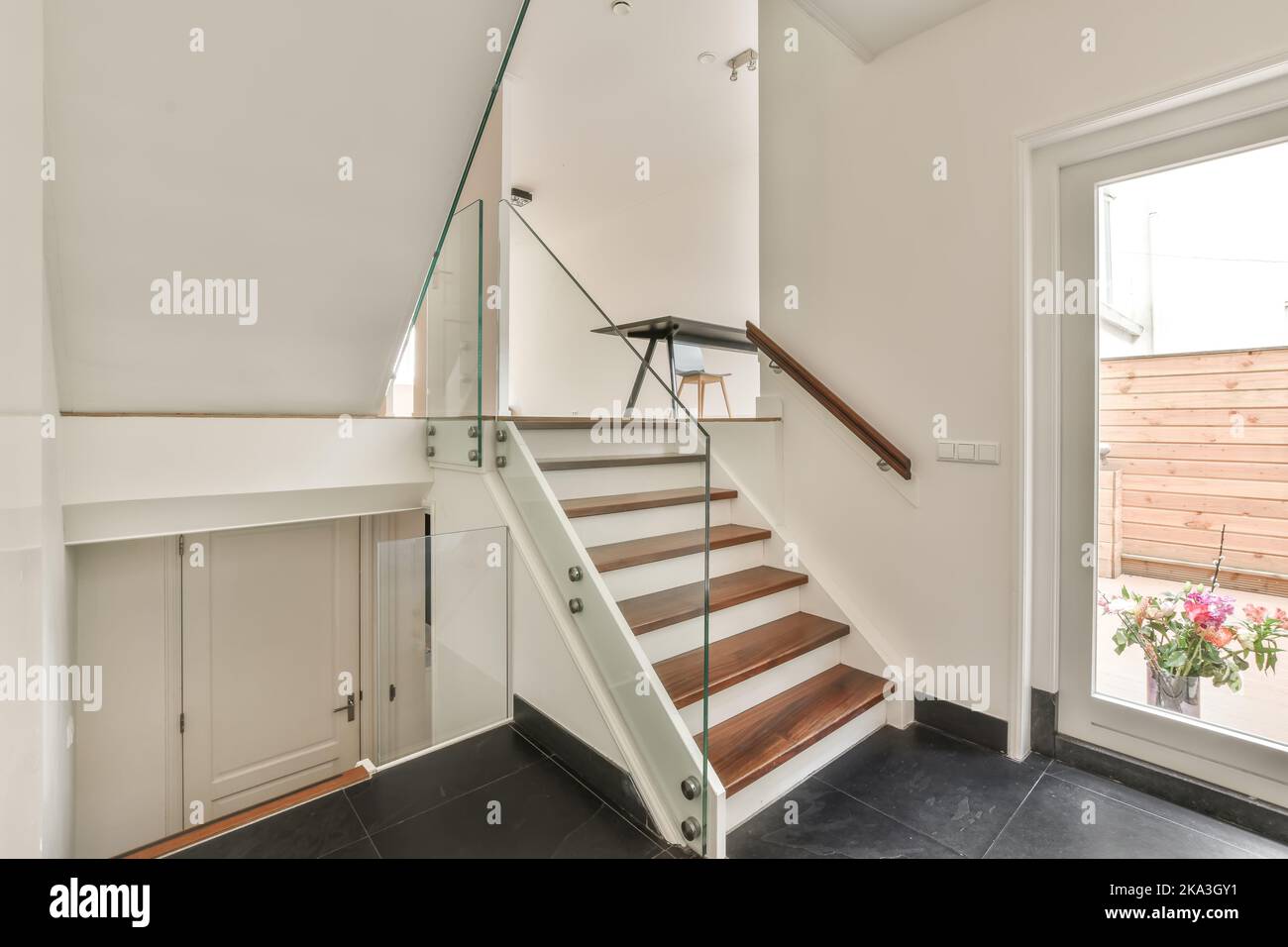 Stairway with wooden steps and glass railings placed light corridor ...