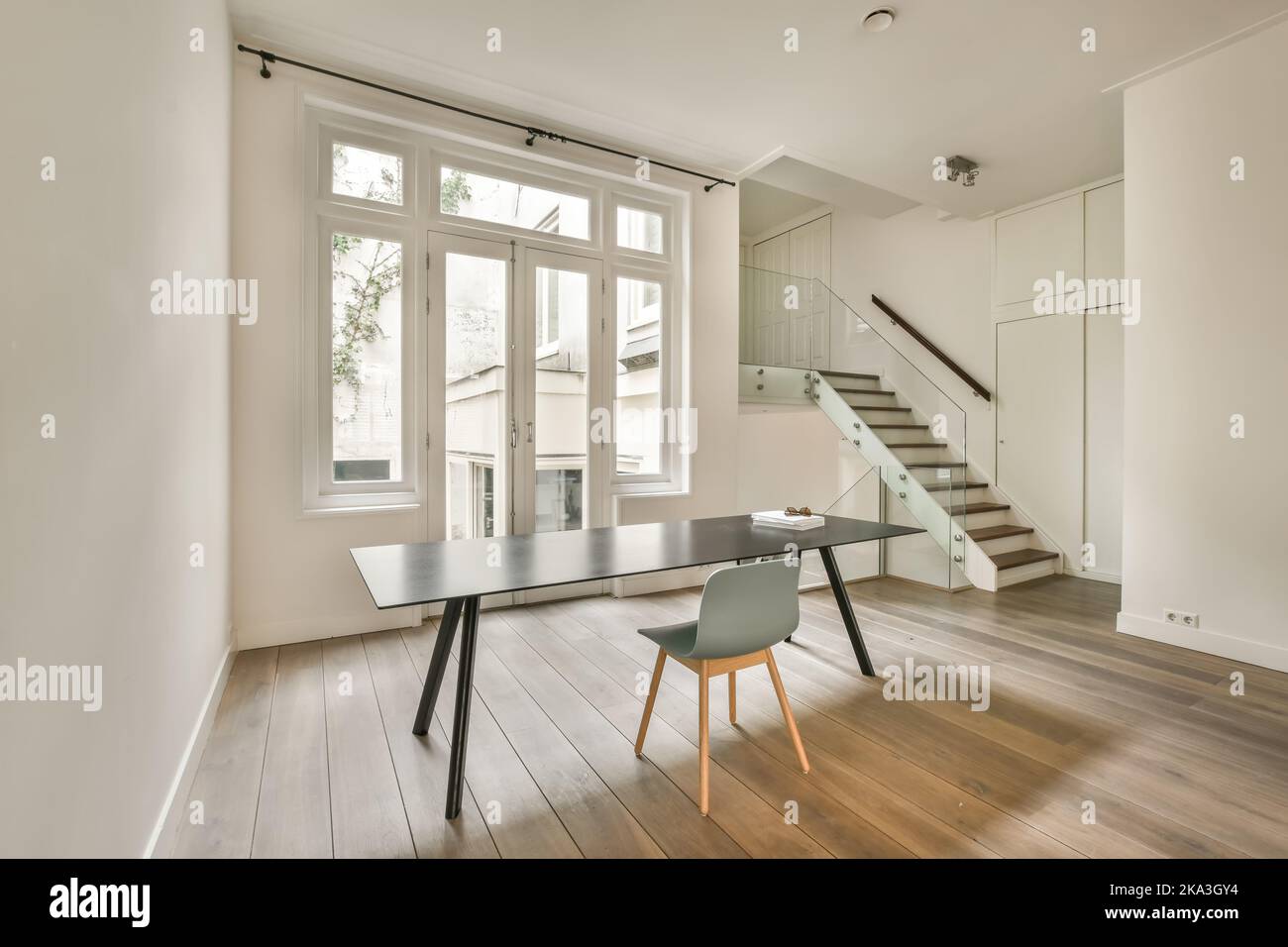 Stairway with wooden steps and glass railings placed in light spacious ...