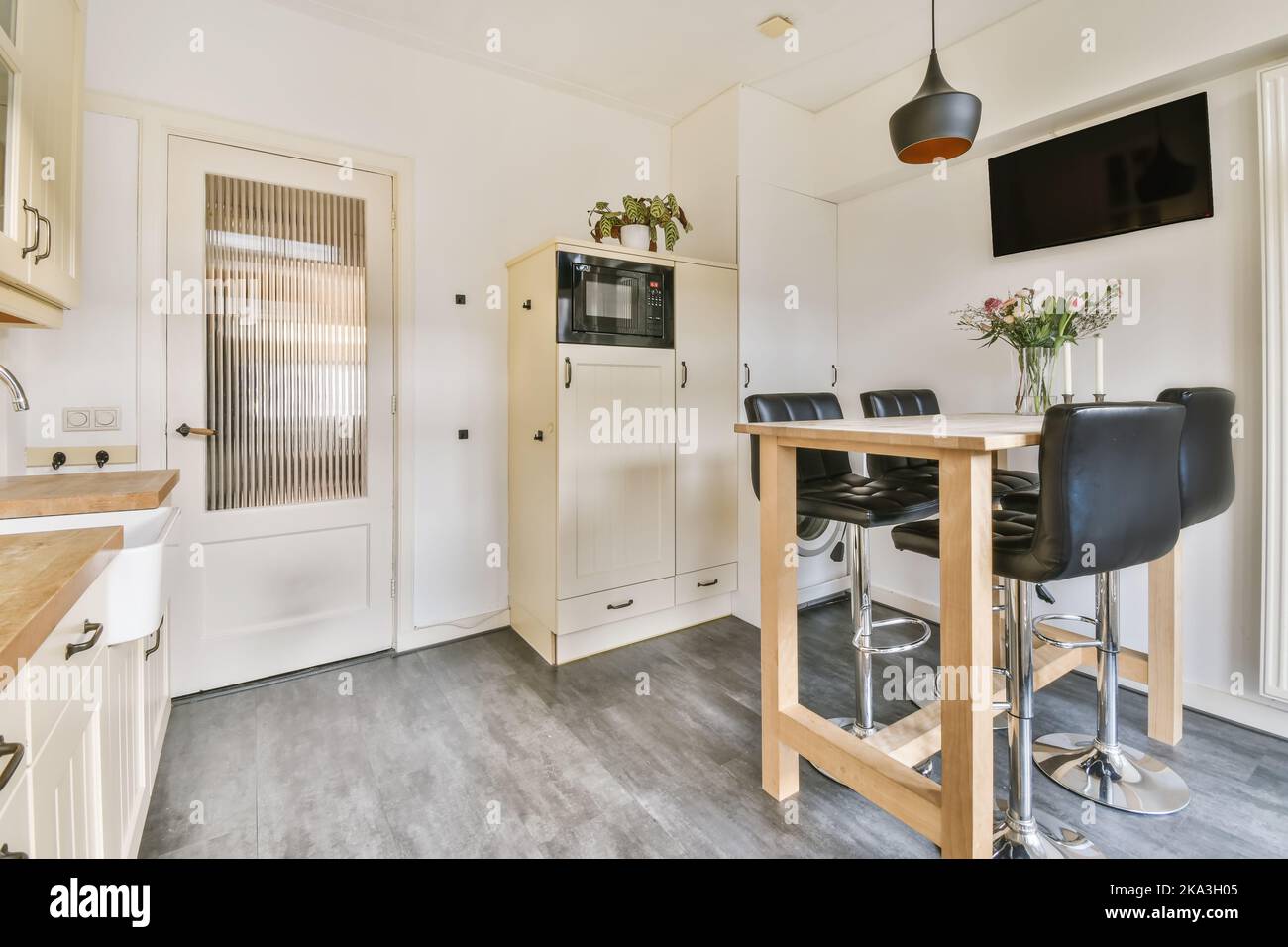 Wooden counter in modern kitchen with elegant chairs and parquet floor ...