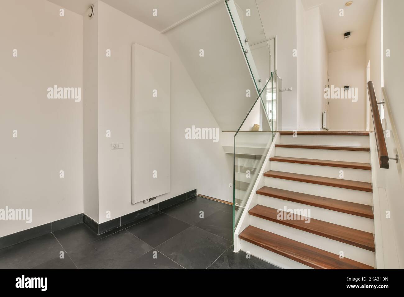 Stairway with wooden steps and glass railings placed light corridor ...