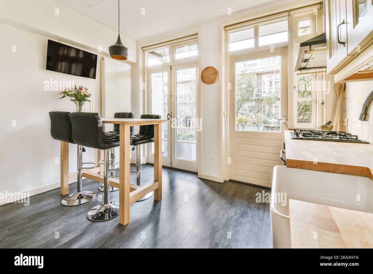 Wooden counter in modern kitchen with elegant chairs and parquet floor ...