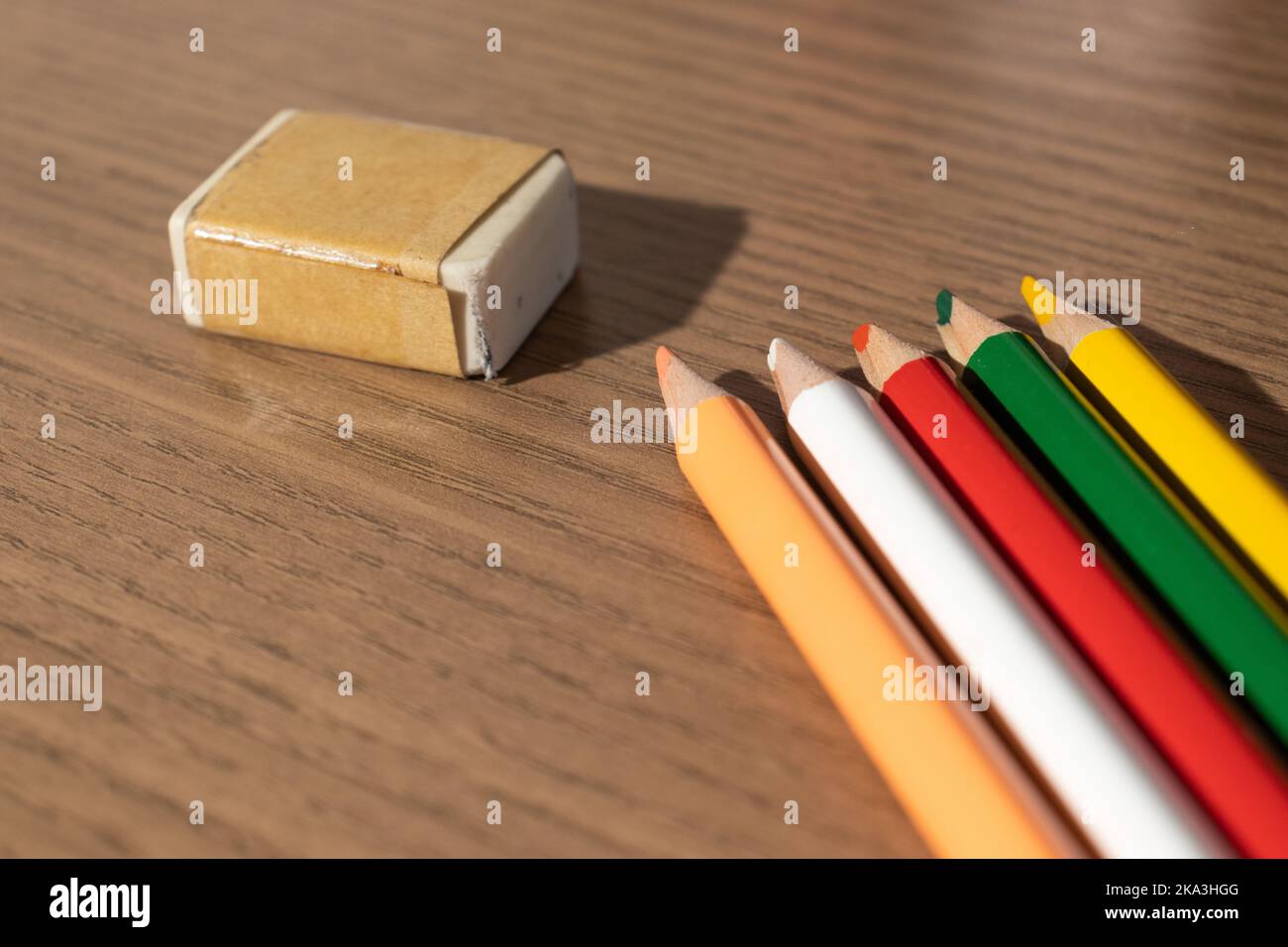 Colored pencils and white eraser on desk table Stock Photo - Alamy