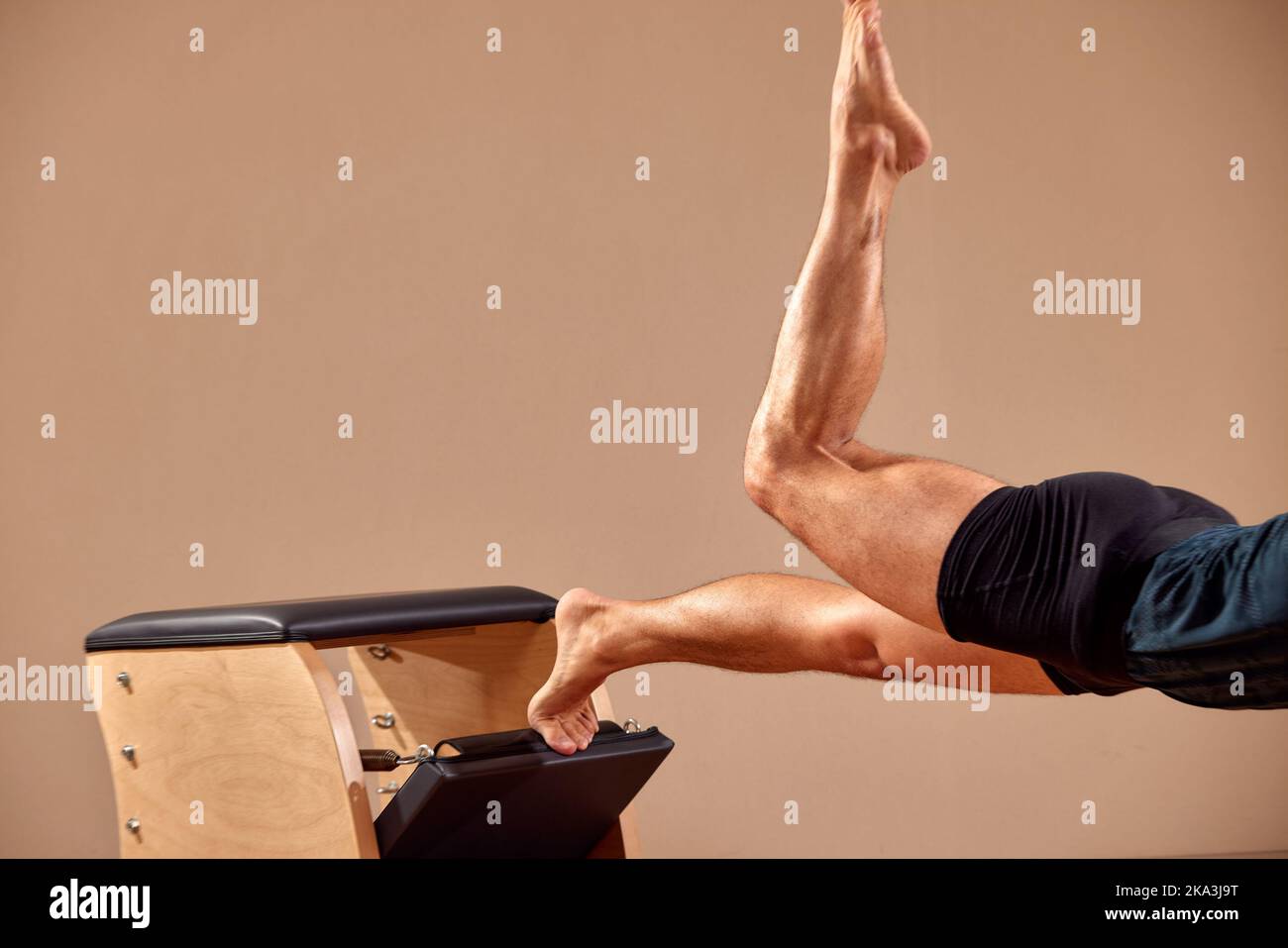 Handsome pilates male instructor performing stretching balance fitness ...
