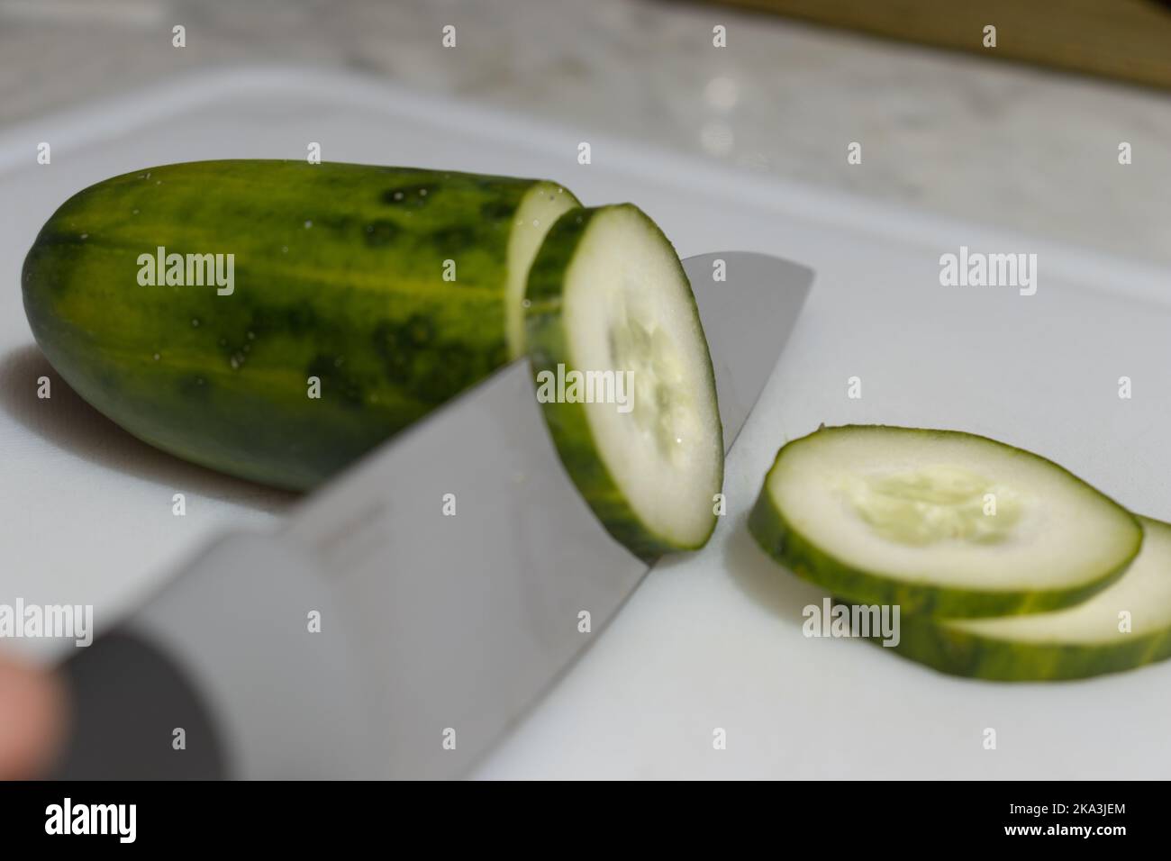 Knife cutting cucumber on white hi-res stock photography and images - Alamy