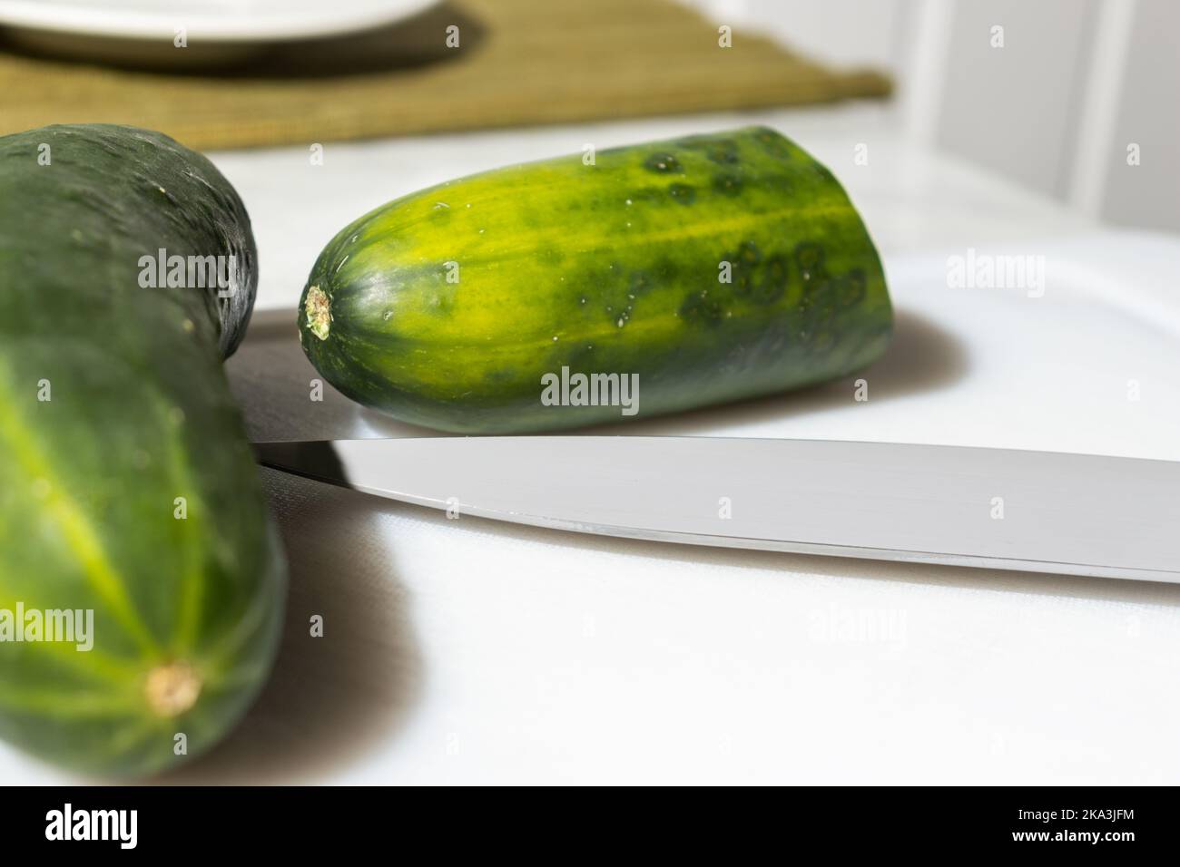 Knife cutting cucumber on white hi-res stock photography and images - Alamy