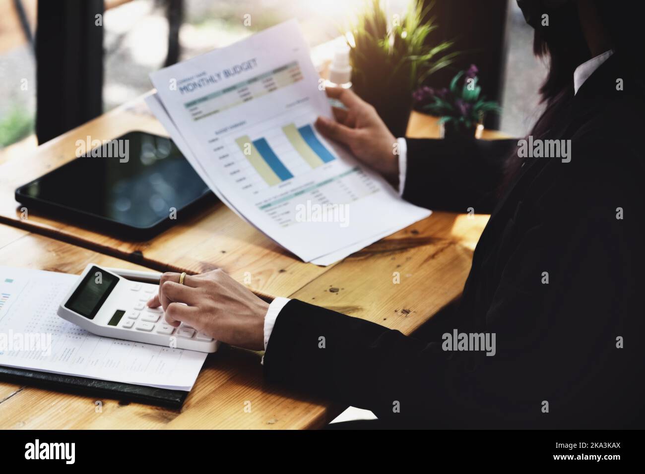 Business woman using calculator to review balance sheet annual using ...