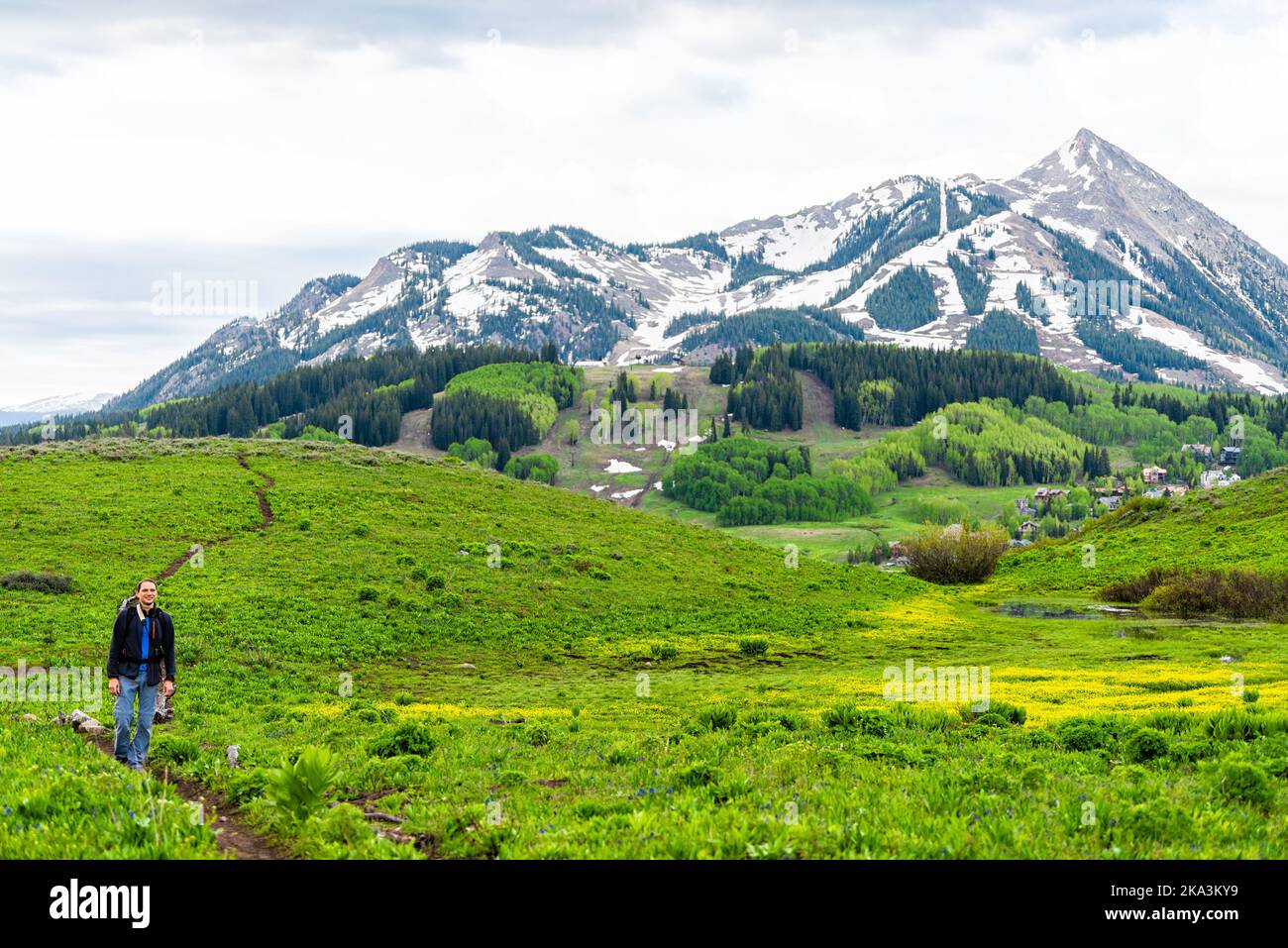 Happy young man standing on Snodgrass trail hike with camera and view ...