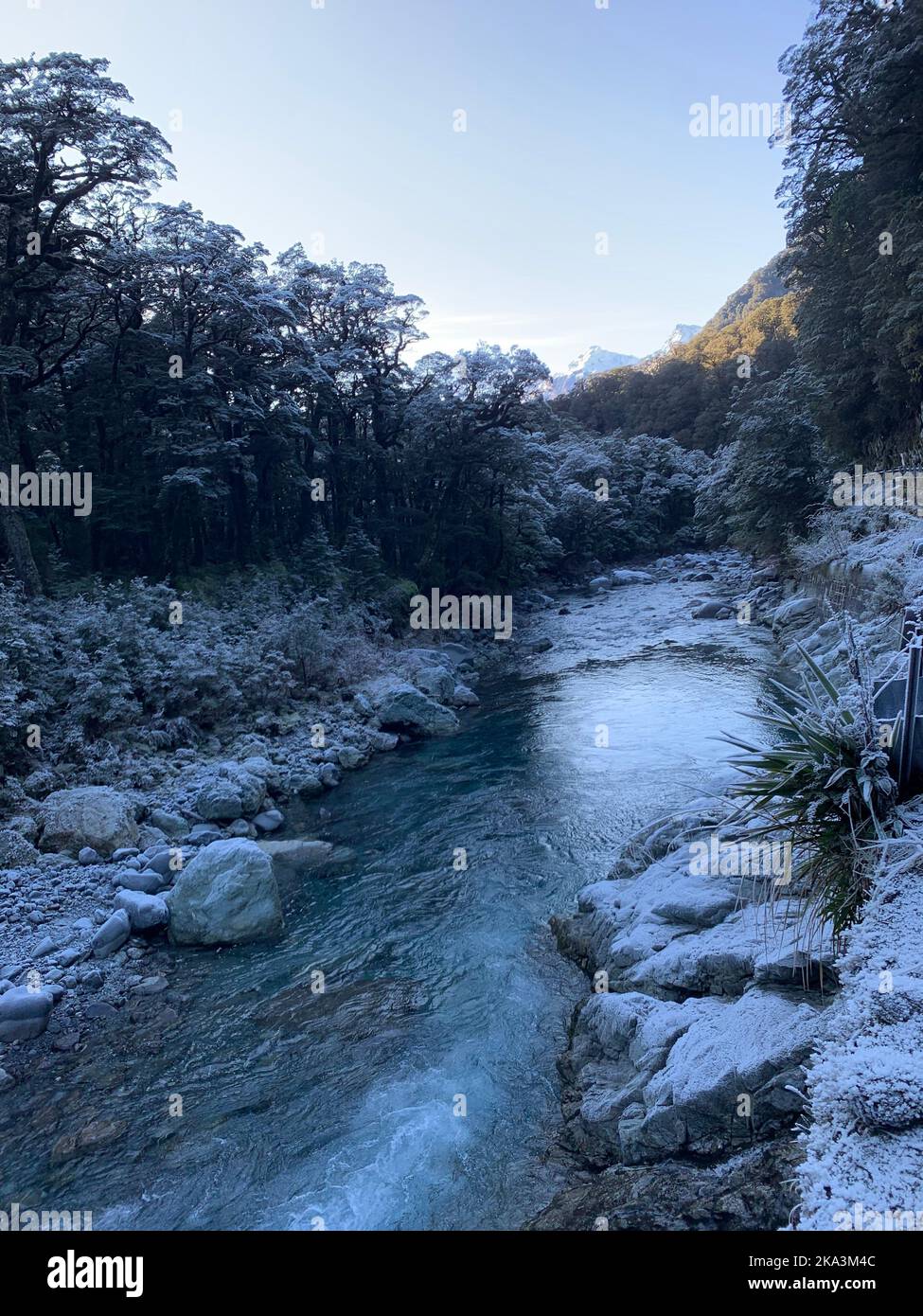 A vertical shot of a river streaming through the snowy nature Stock ...