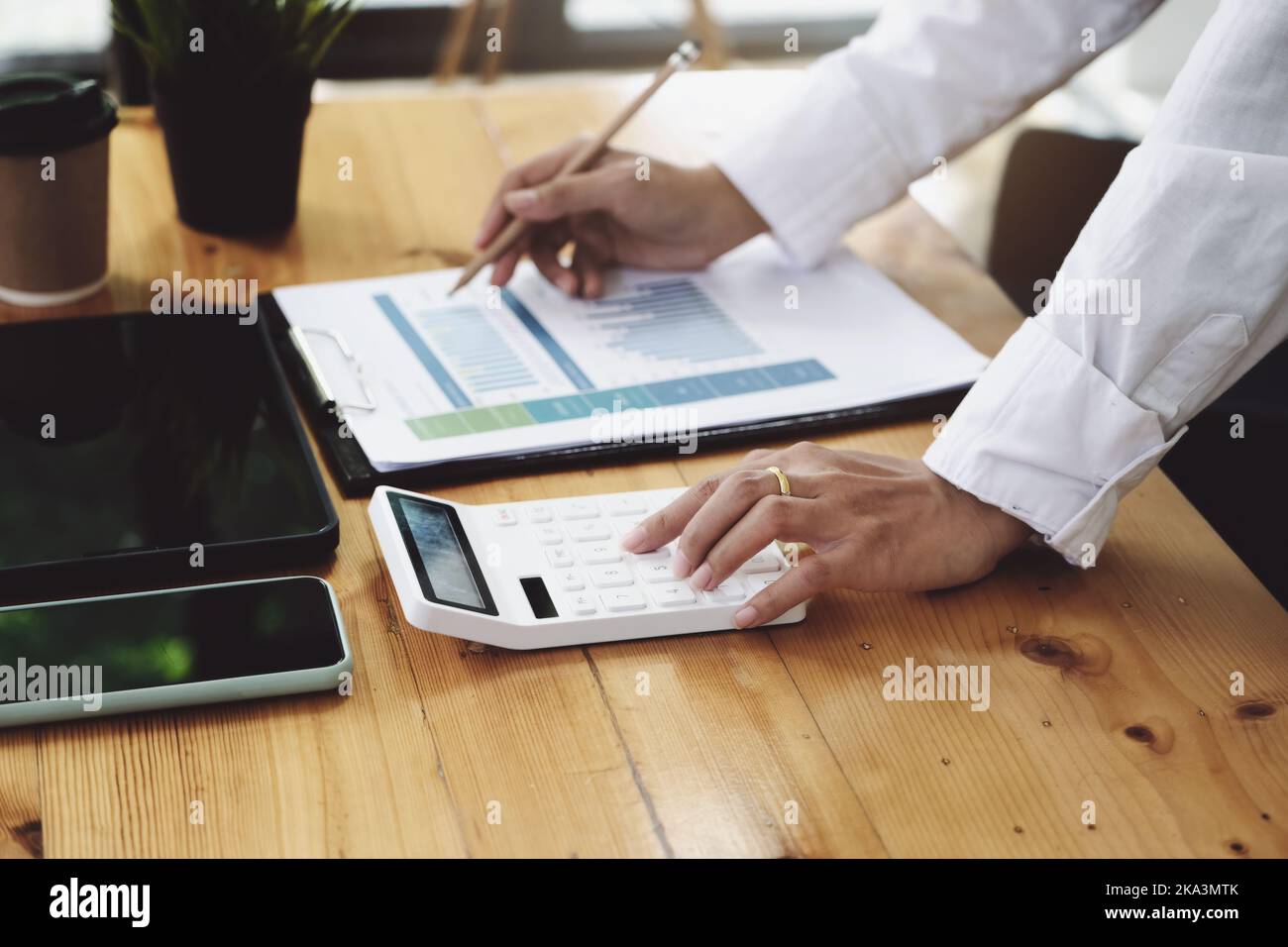 Business woman using calculator to review balance sheet annual using ...