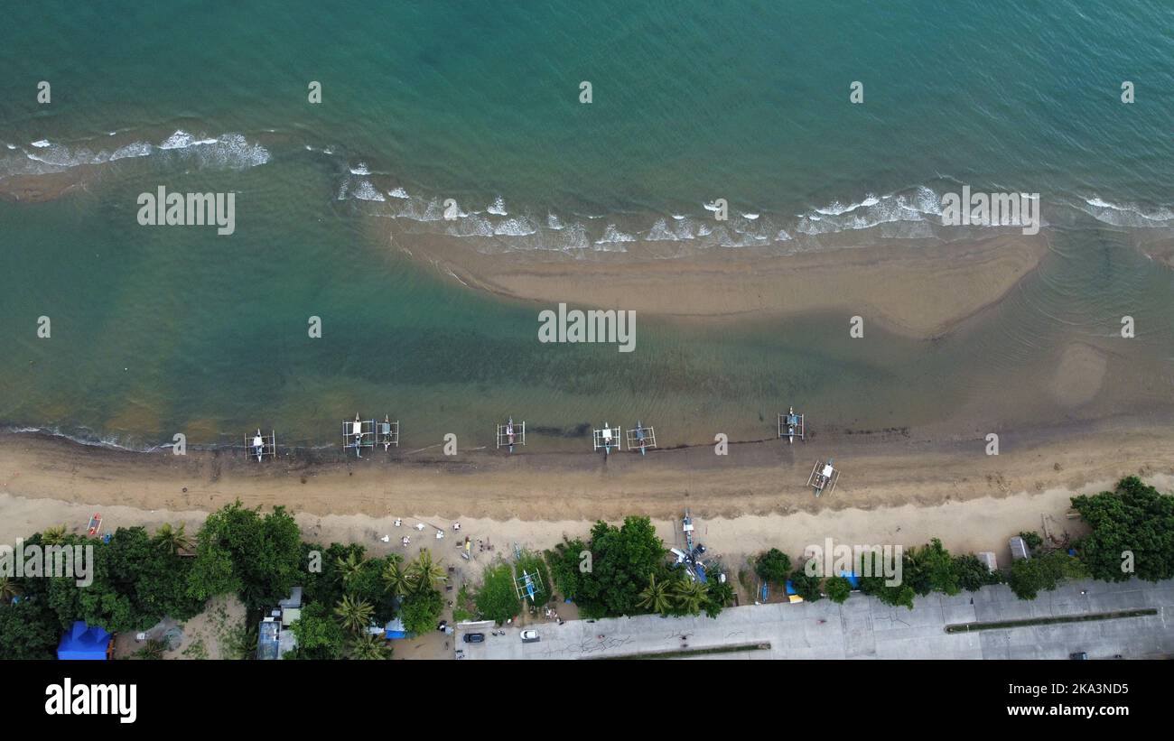 An aerial drone shot overlooking Bayawan City Boulevard and the ocean ...