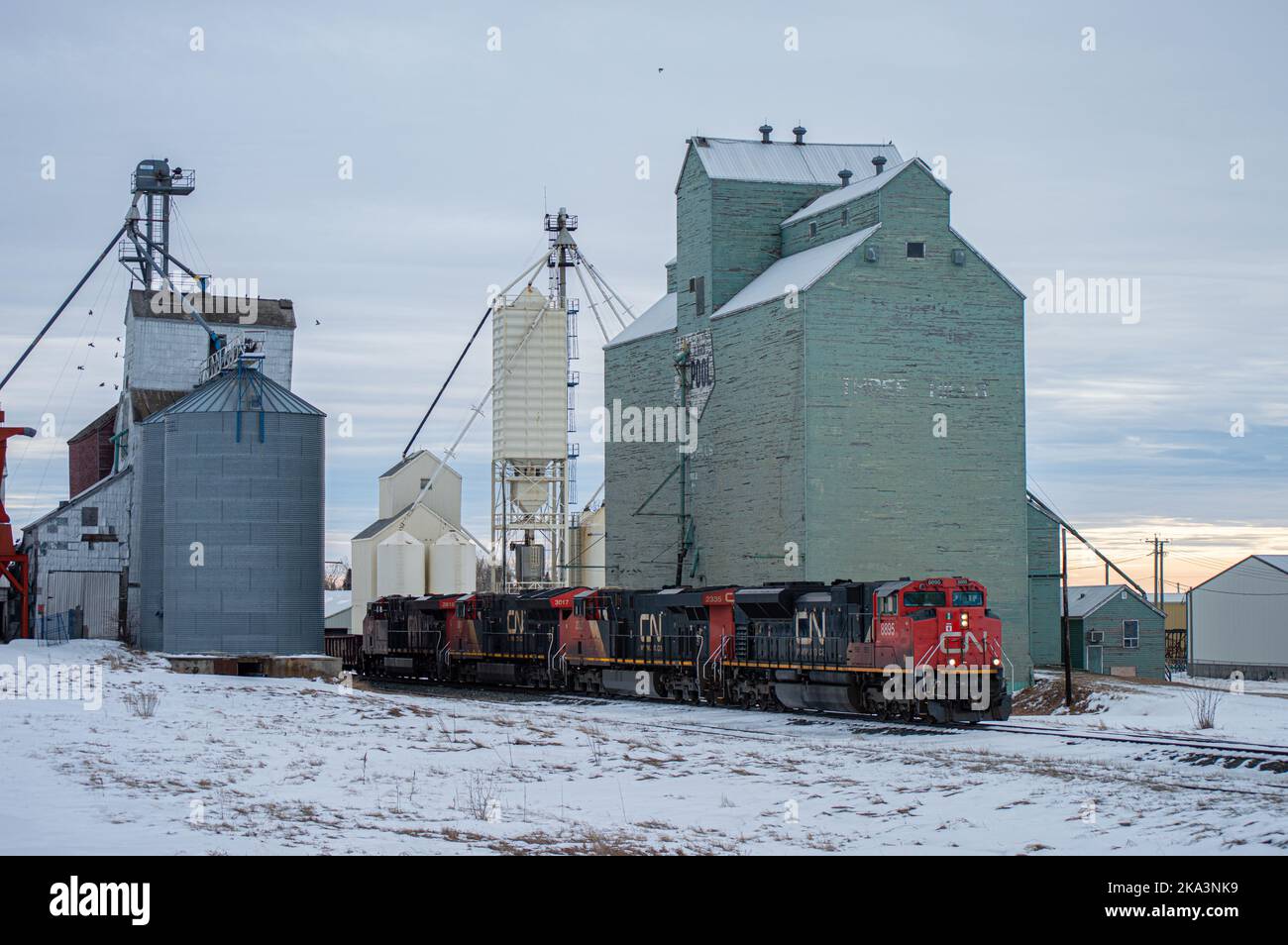 A freight train with grain elevators on the snowy railroad in Three ...