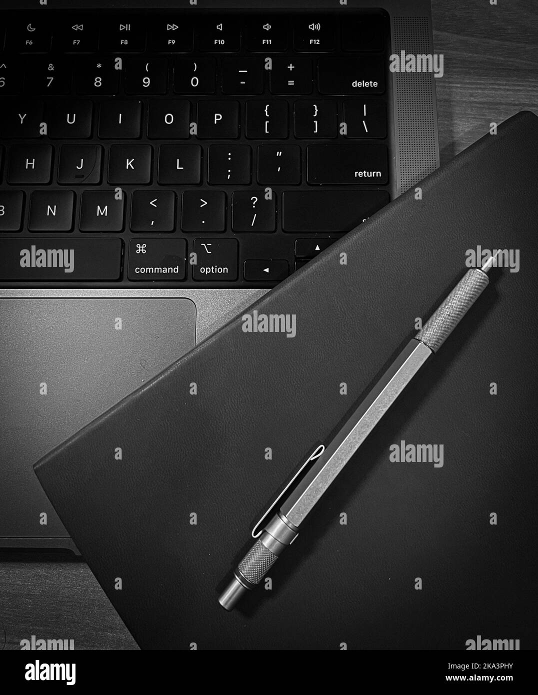 A vertical top view of a notebook with a pen on a keyboard shot in ...