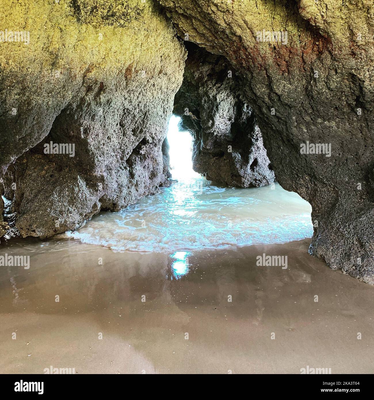 A beautiful view of sea cave by the sandy beach Stock Photo - Alamy