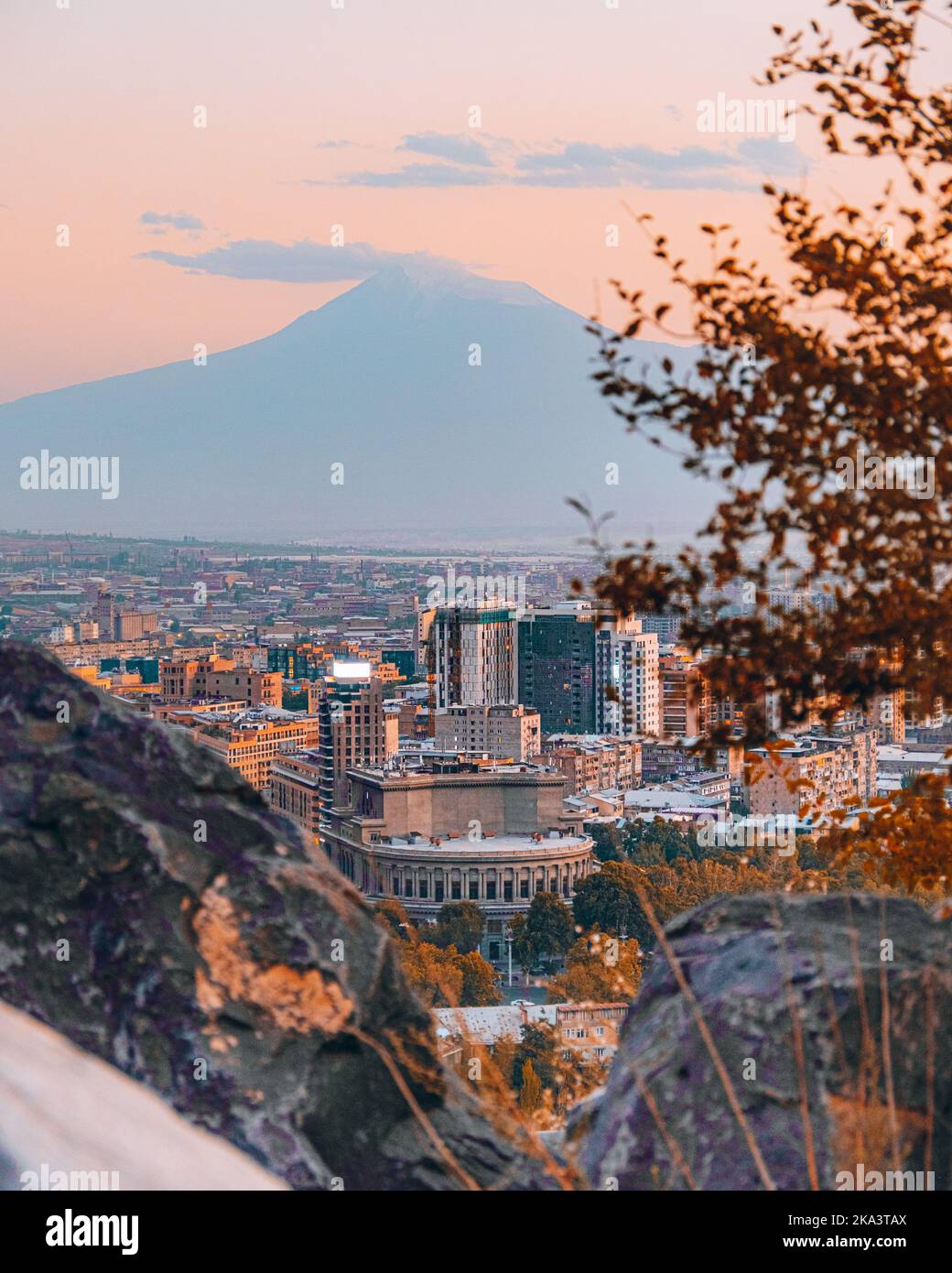A vertical breathtaking view of the Yerevan cityscape behind the rocks ...
