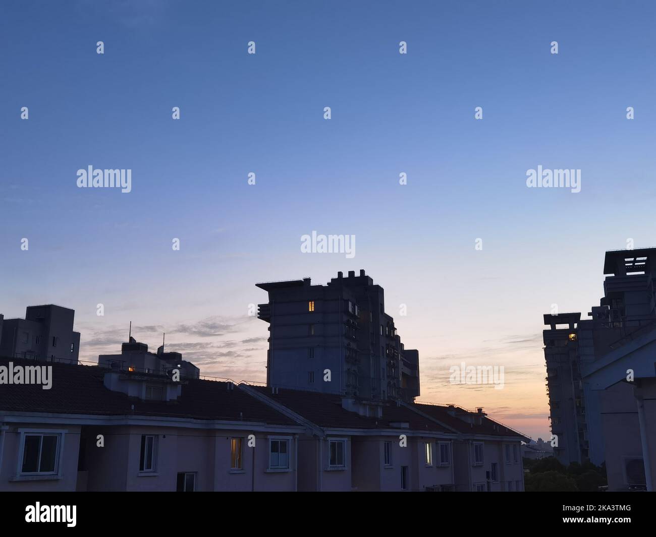 An aerial view of building roofs under blue sky during sunset Stock ...