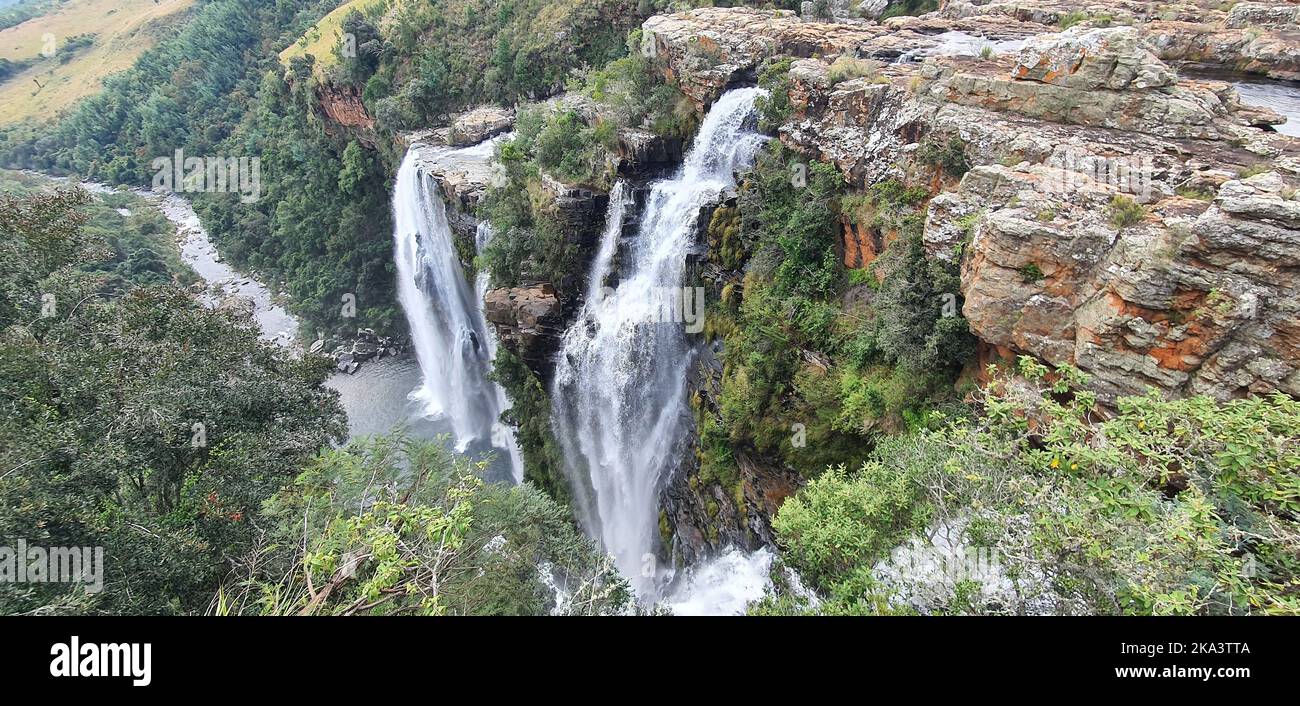 An aerial view of a rocky cliff and waterfall in the forest of South ...