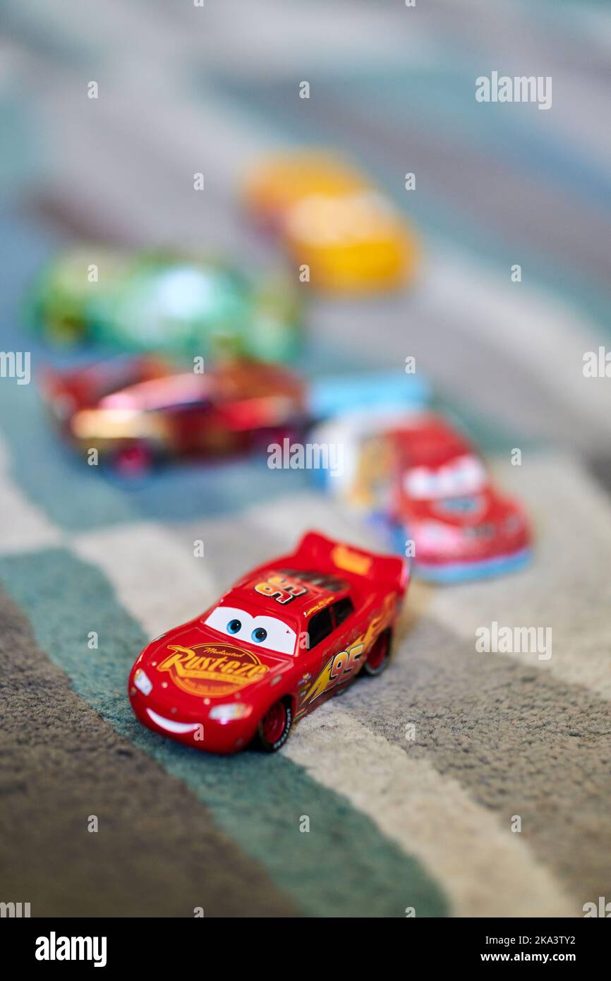 A vertical shallow focus of toy cars on a carpet - Lightning McQueen ...