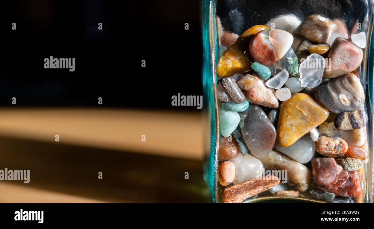 Glass bottle half full of rounded pebbles and rocks Stock Photo - Alamy