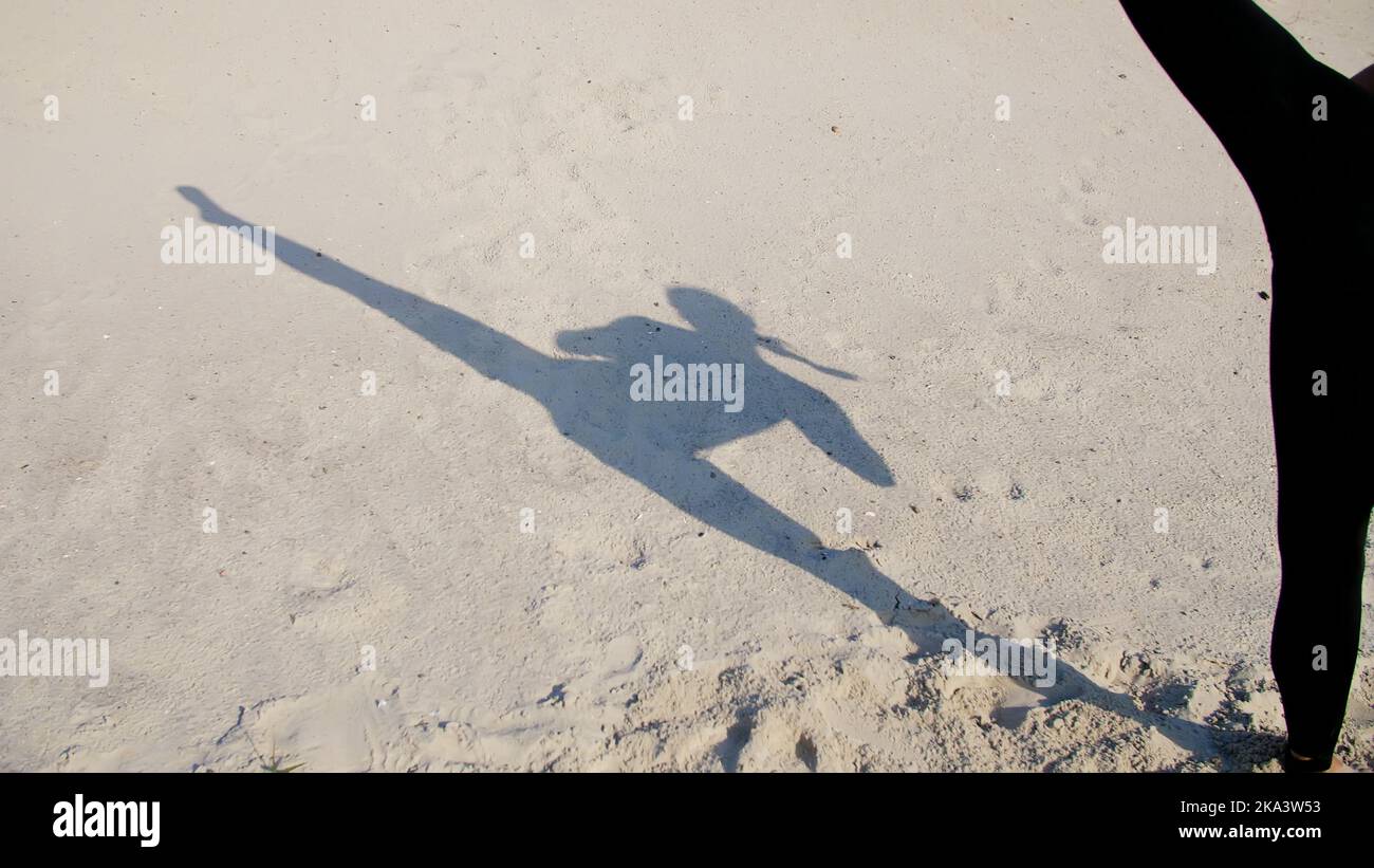 On the sand you can see the shadow, the silhouette of an athletic girl ...