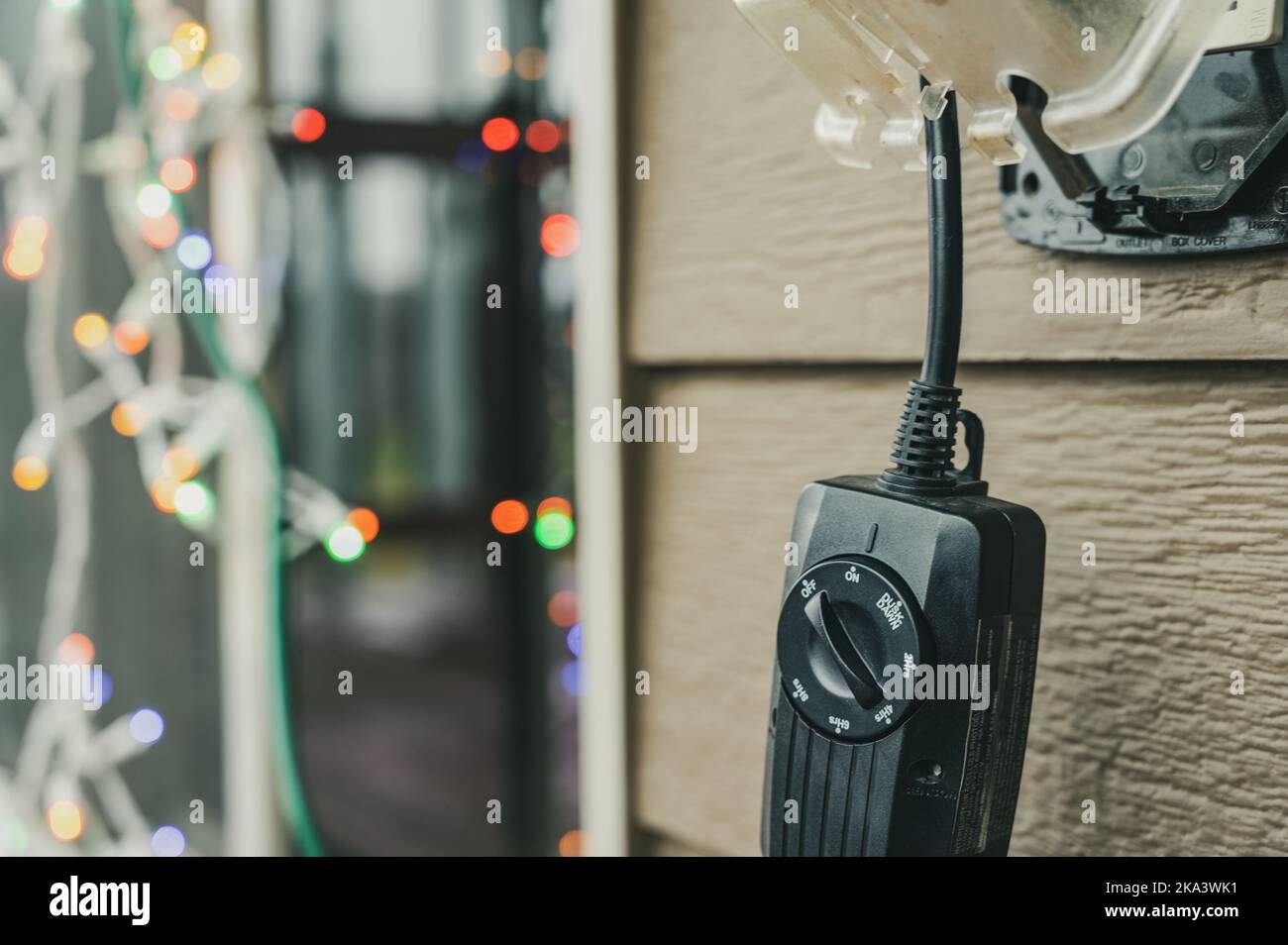 Outdoor timer and GCFI outlet with cover. Blurred christmas lights in ...