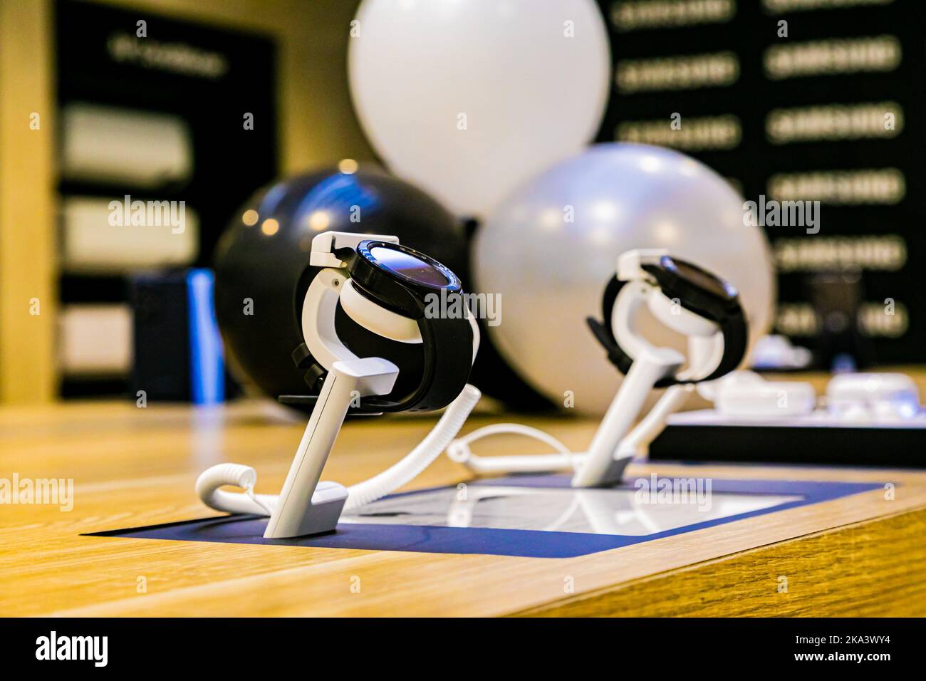 A smartwatch displayed in a Samsung store with balloons on the ...